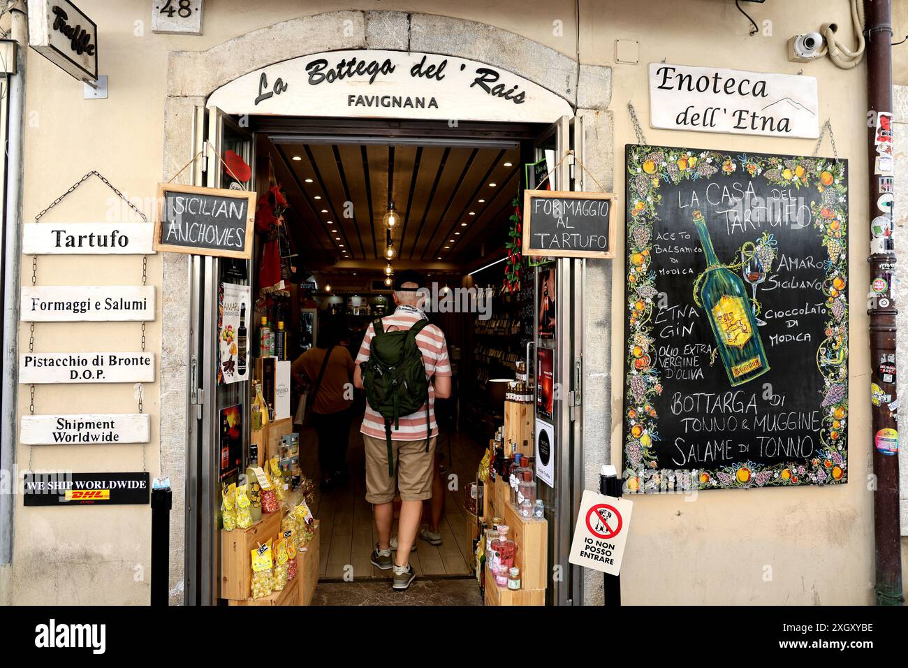Man walking into wine and smallgoods shop in Taormina in Sicily Italy ...
