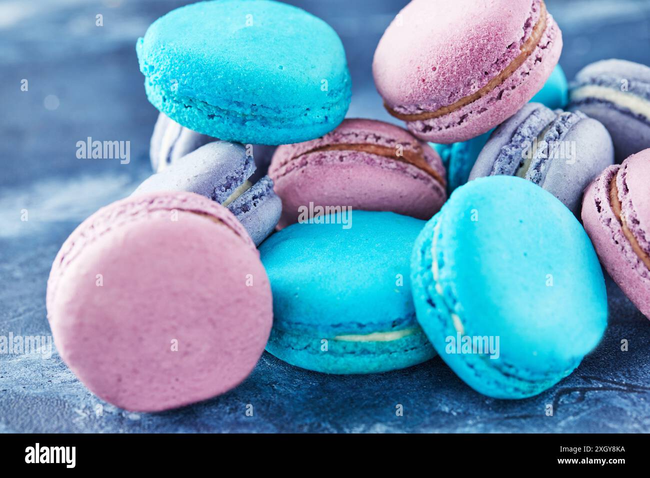 Multi-colored macarons of blue cheese and blueberry flavors on blue ...