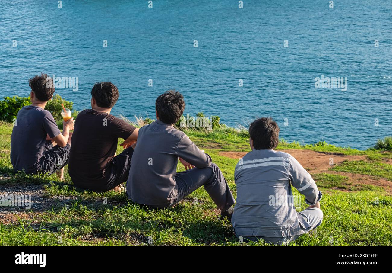 Back view Group of young Asian men friends siting together on summer ...