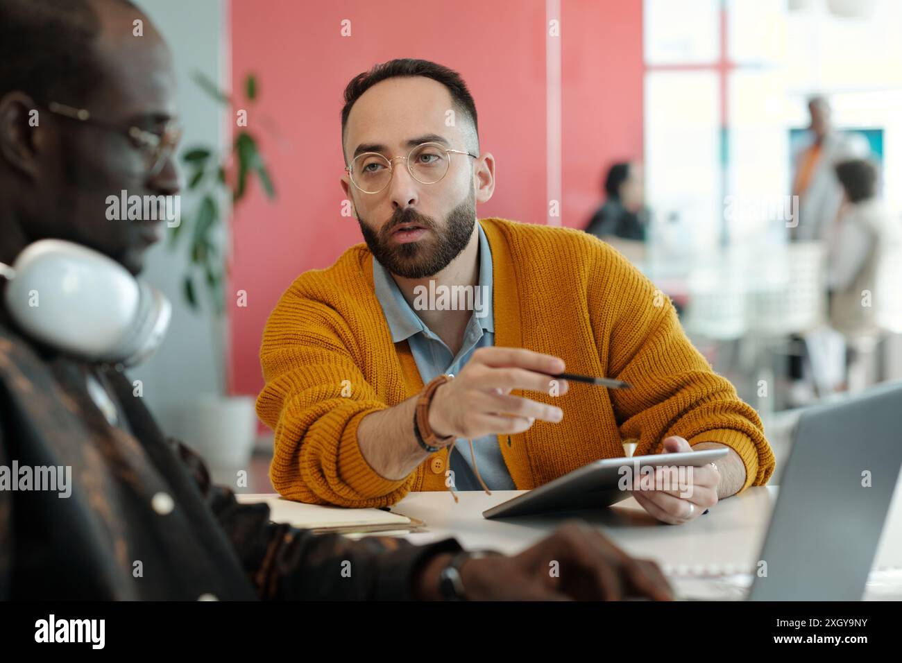 Diverse colleagues exchanging ideas and working on project in modern ...