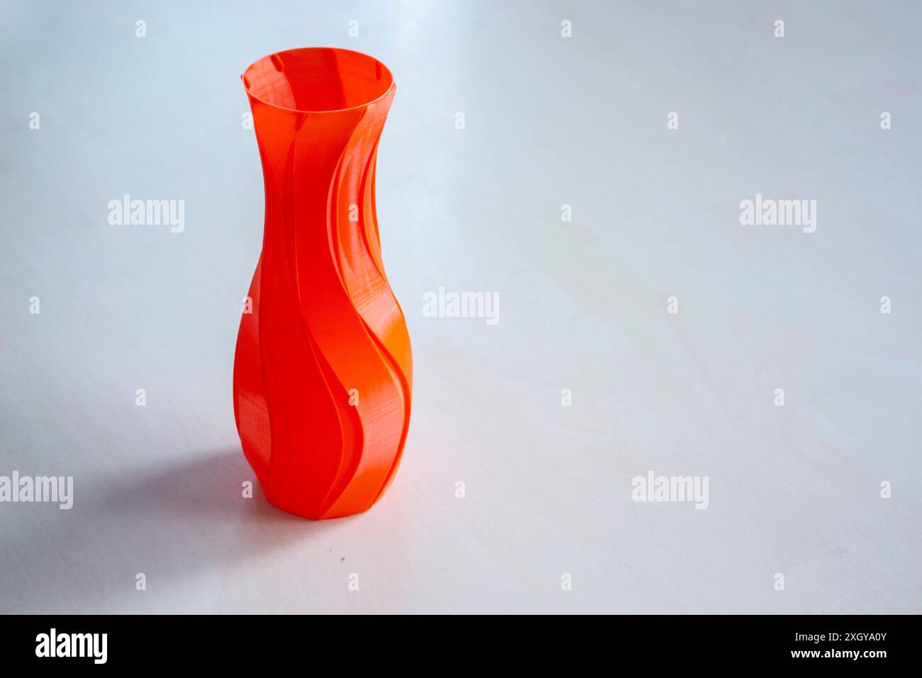 Object in the form of a vase of red color printed on a 3D printer ...