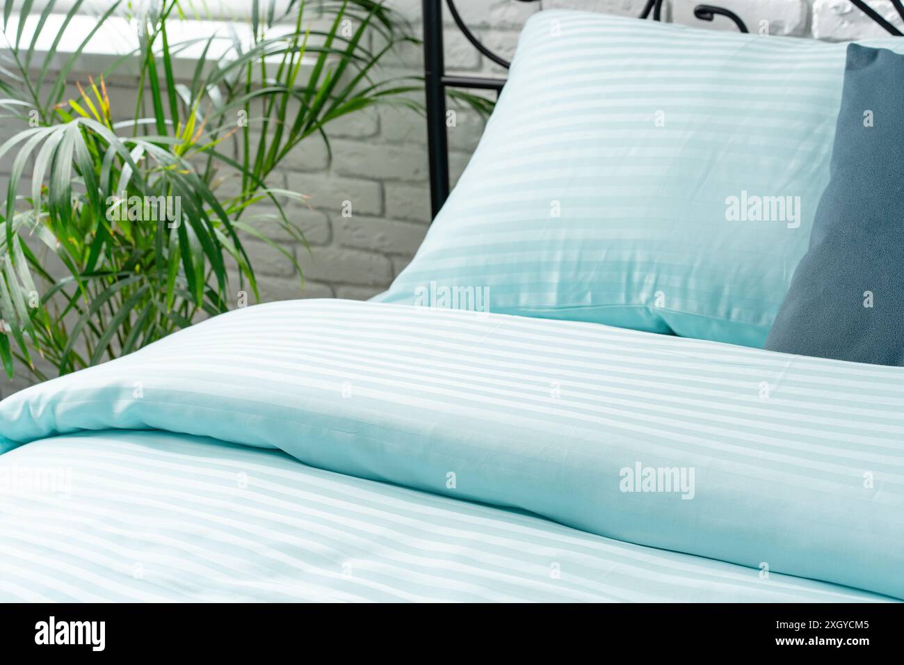 Mint Green Striped Bedding on a Black Metal Frame Bed Stock Photo - Alamy