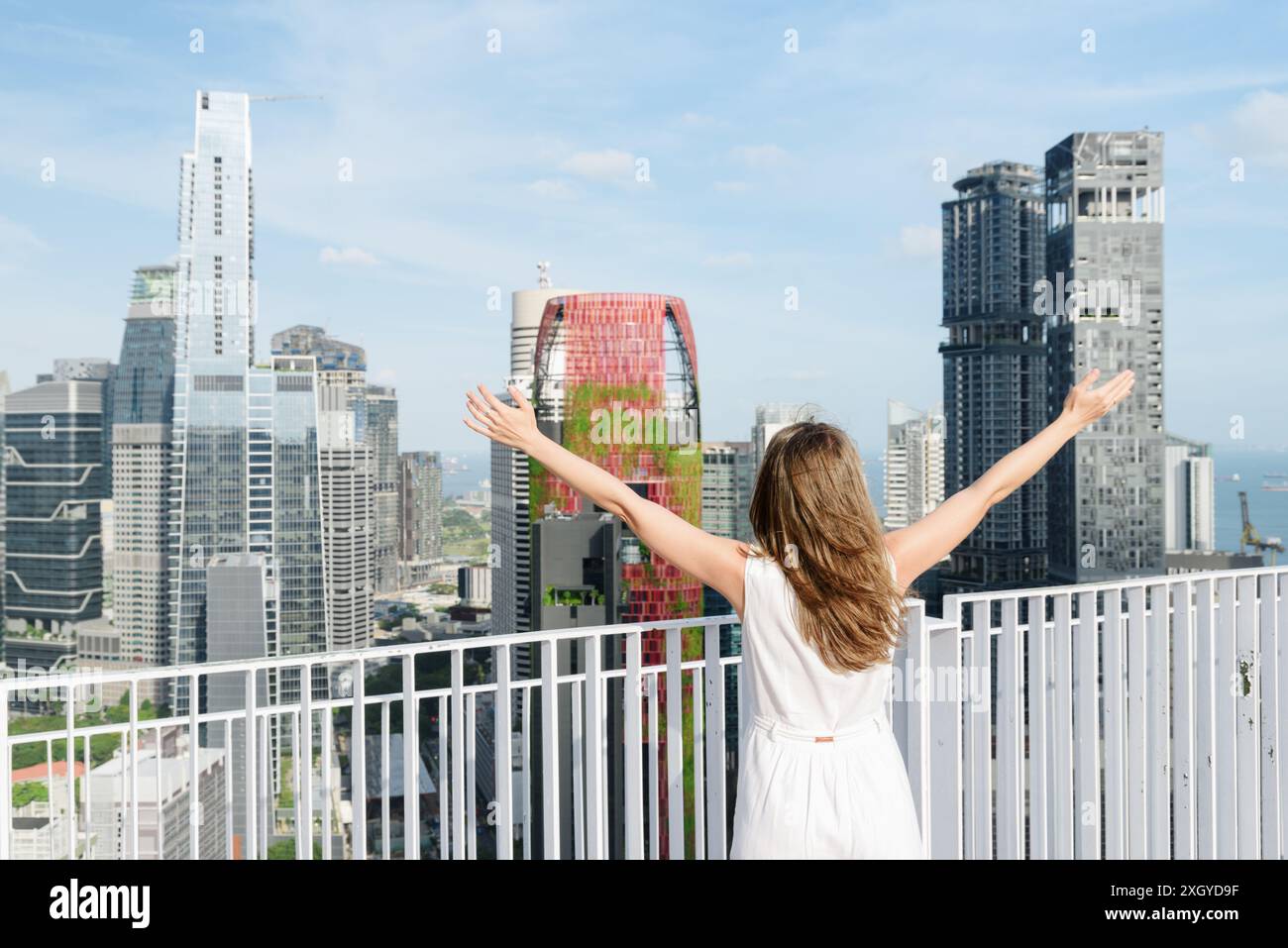 Girl with raised arms to the sky enjoying fantastic cityscape from ...