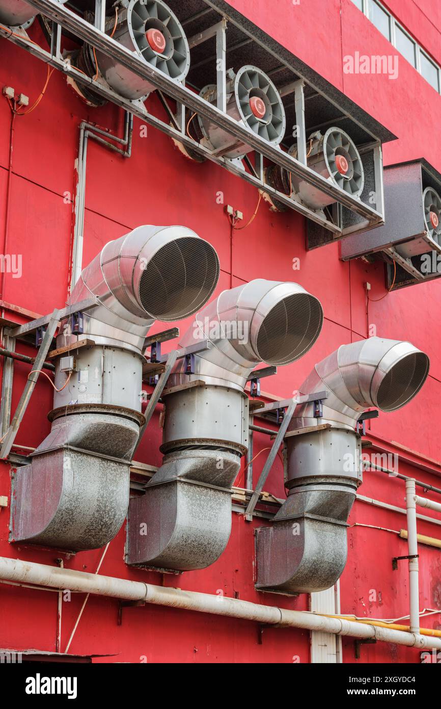 Ventilation pipes outside a red building. View of venting system. Urban ...