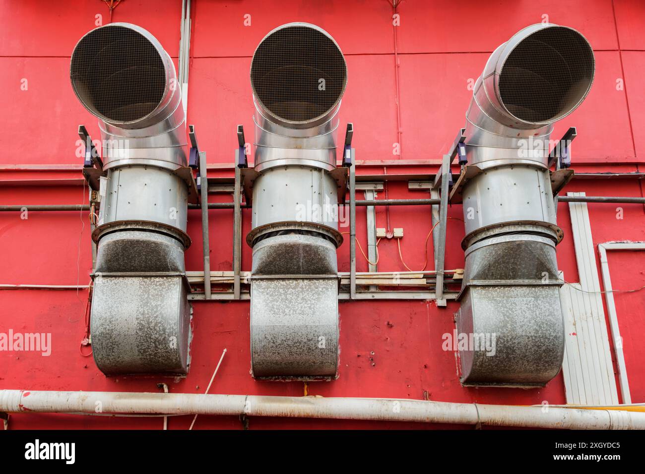 Ventilation pipes outside a red building. View of urban venting system ...