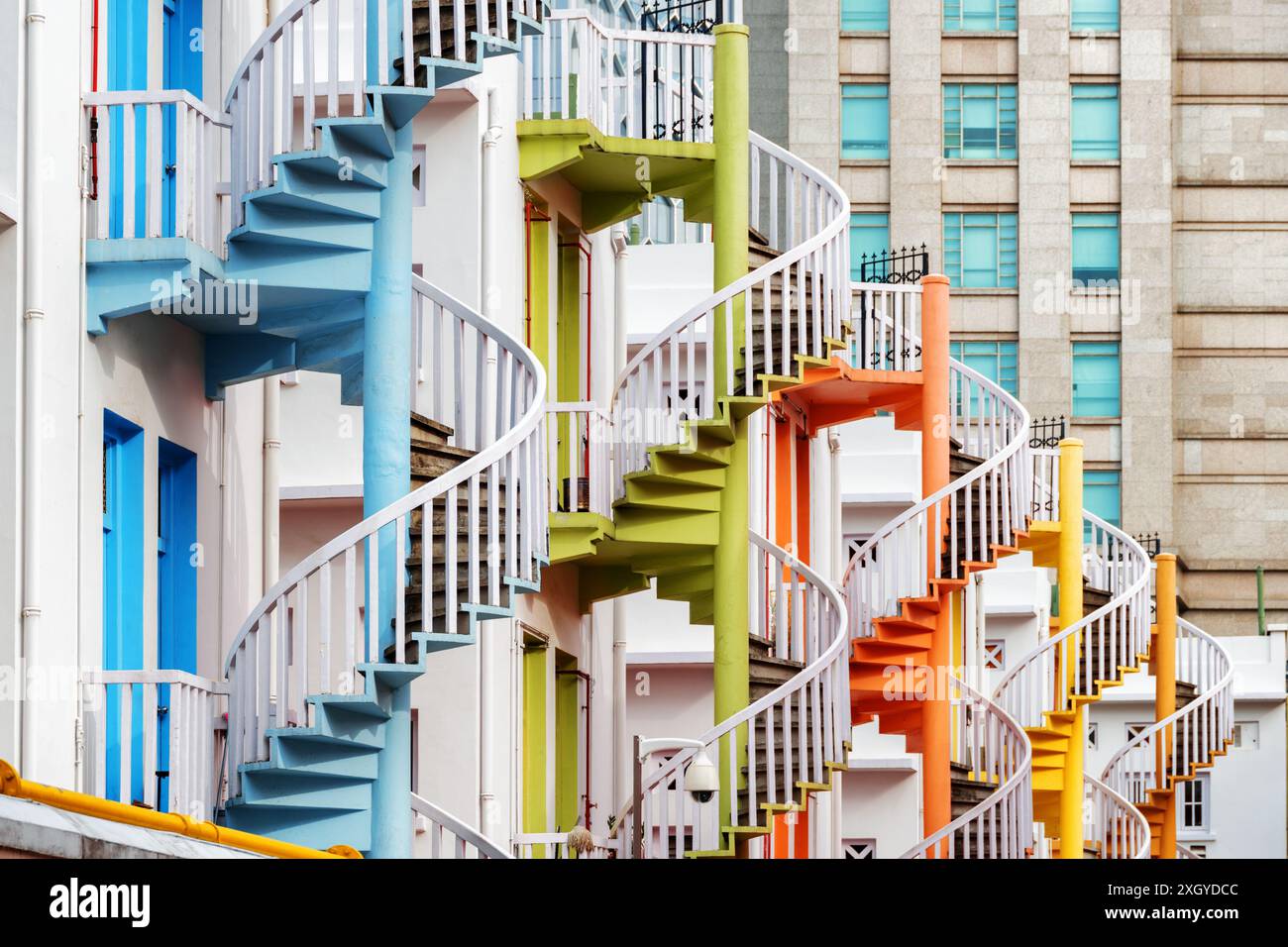 Colorful exterior spiral staircases outside a whitewashed building in ...