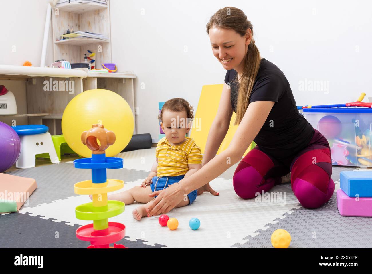 Physiotherapist assisting a young child with neurodevelopmental ...