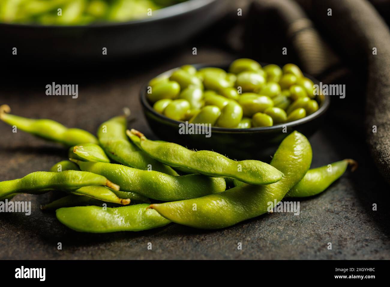 Green edamame pods. Fresh soybeans on a black table Stock Photo - Alamy