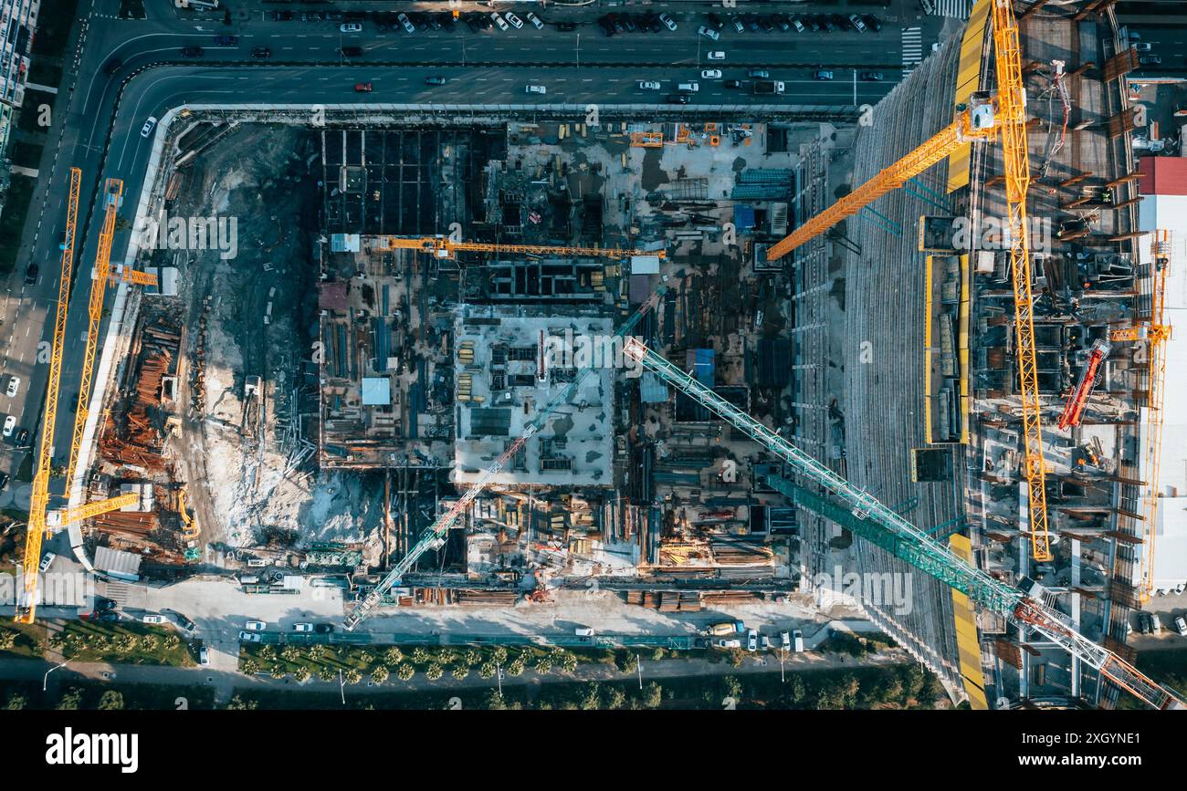 Top down view of large construction site with multiple cranes ...