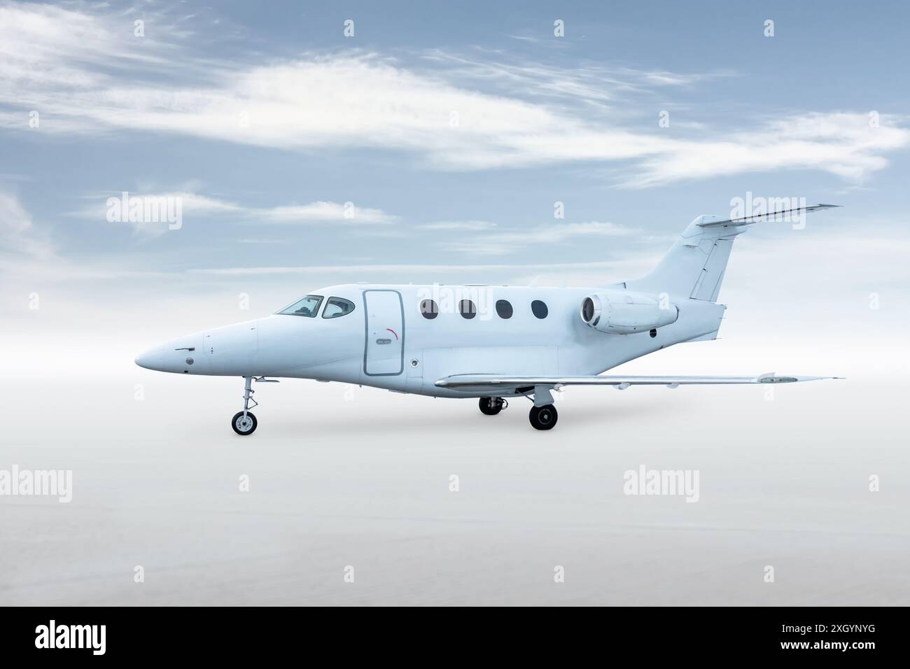 Modern white corporate aircraft isolated on bright background with sky ...