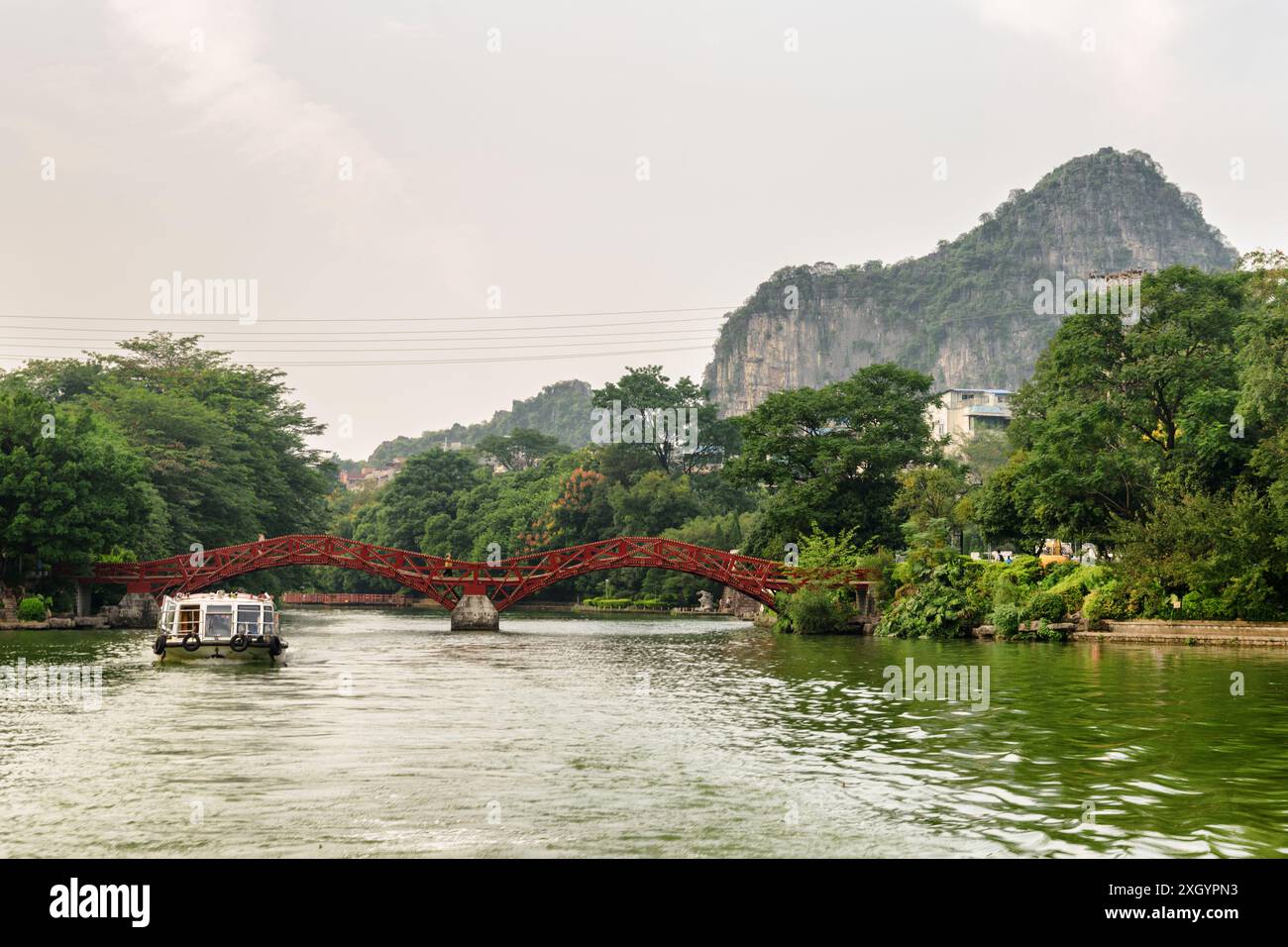 Tourist boat sailing along lake to scenic red bridge in Guilin, China ...