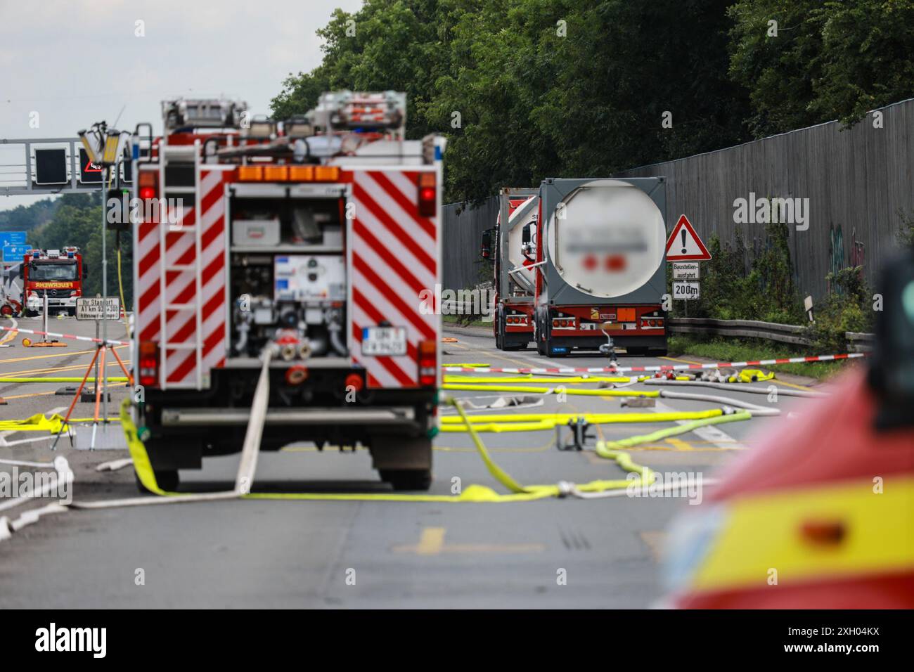 Unna, Germany. 11th July, 2024. Firefighters stand near a hazardous ...