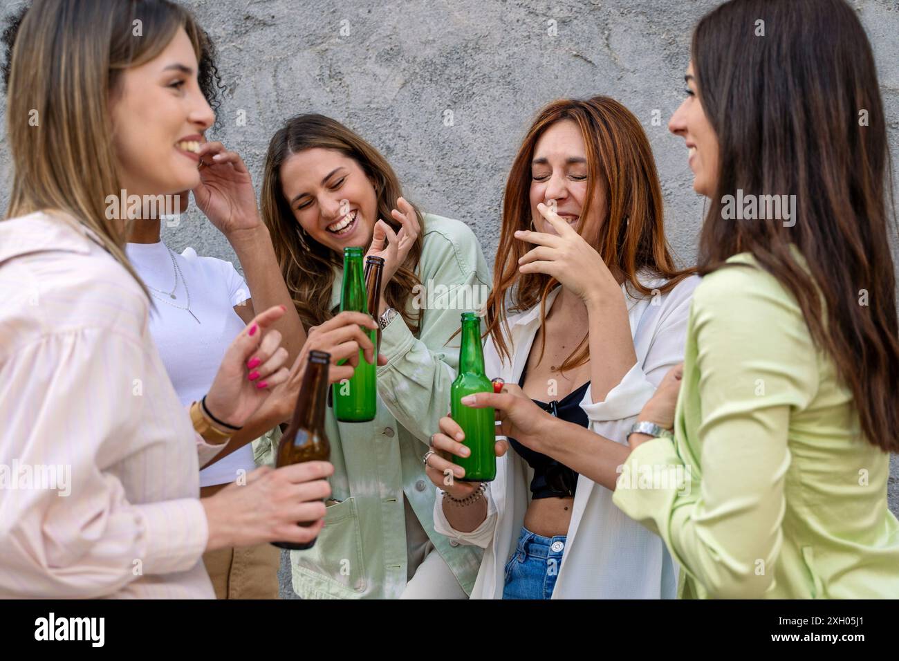Group of young women enjoying beverages and laughter outdoors - Friends ...
