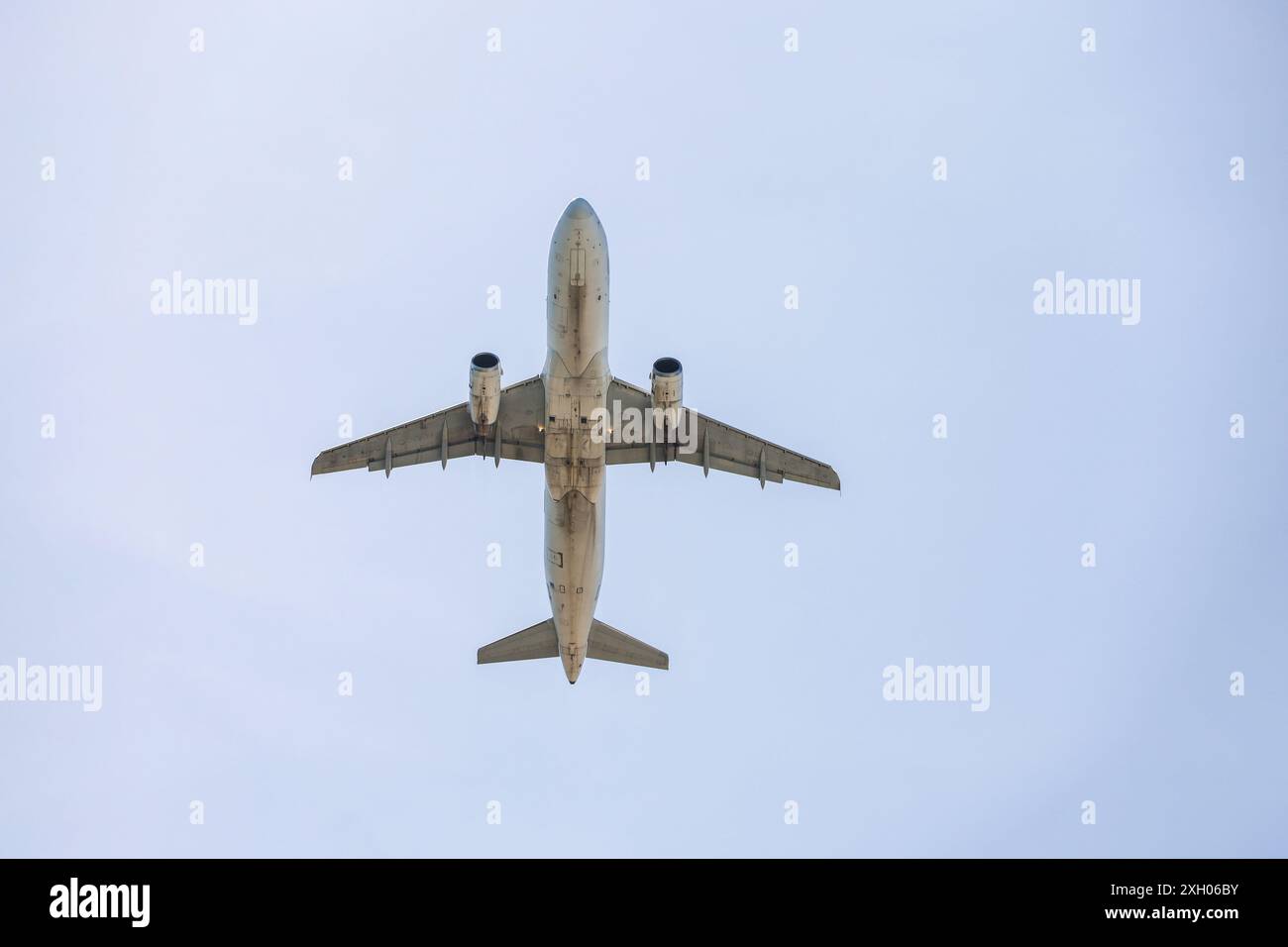 Airplane flying in blue sky, bottom view. Passenger plane at flight ...