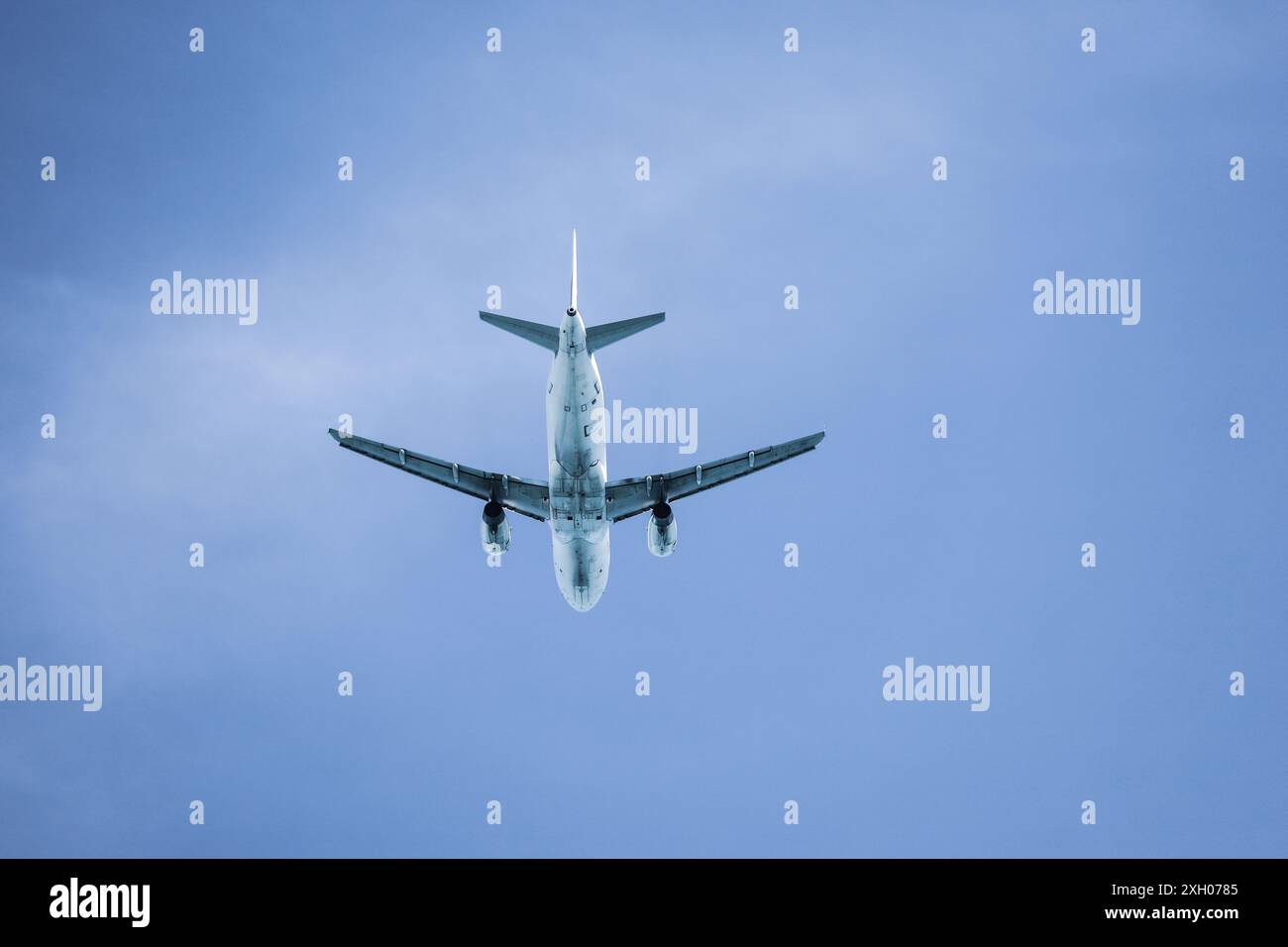 Airplane flying in blue sky, back view. Passenger plane at flight ...