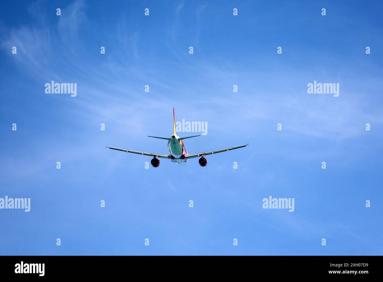 Airplane flying in blue sky, back view. Passenger plane at flight ...