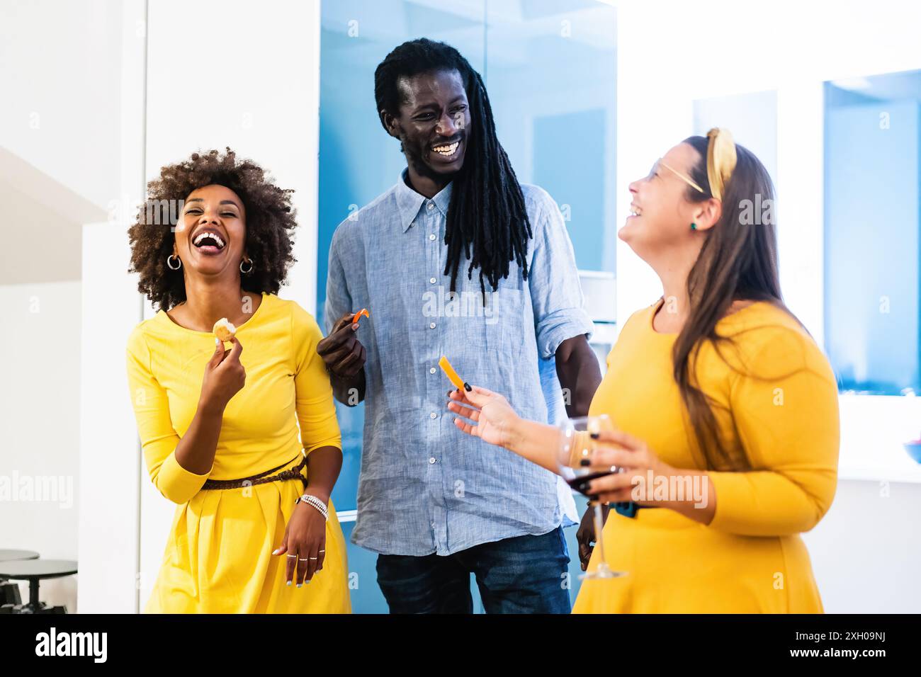 Three diverse friends enjoy a lighthearted moment at a lively dinner ...