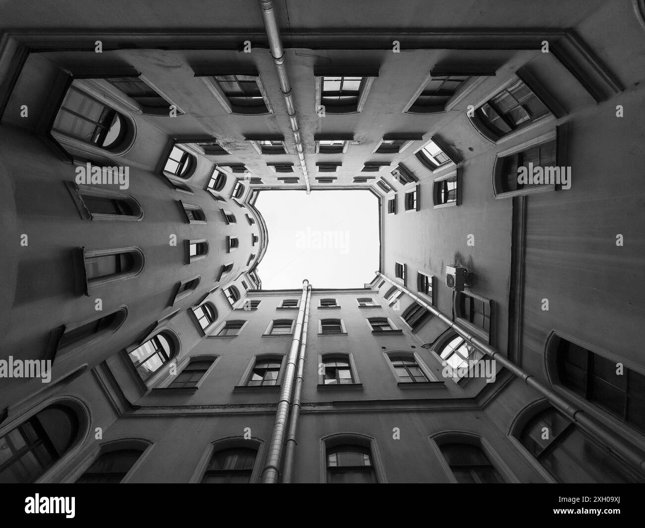 Black and white image of a narrow courtyard in an old building viewed ...