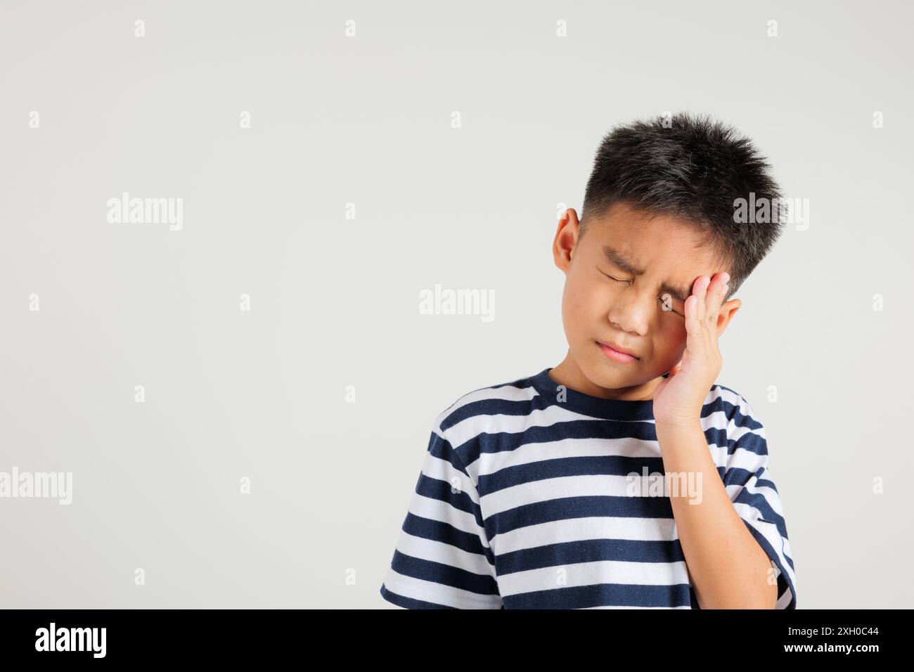 Portrait of Asian young kid boy sad tired strain face holding hold head ...