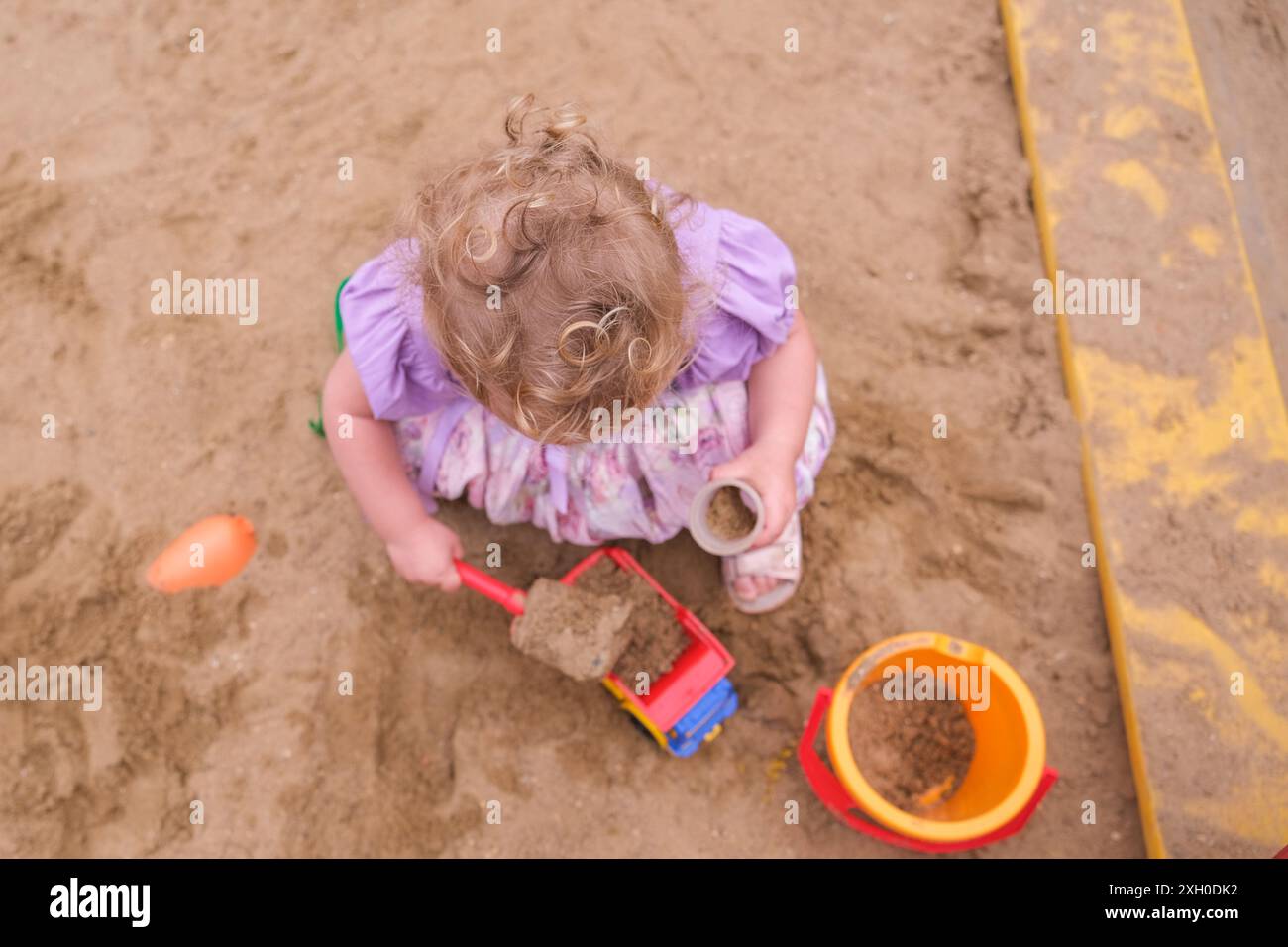 Child playing in the sandbox in the playground in the courtyard of a ...
