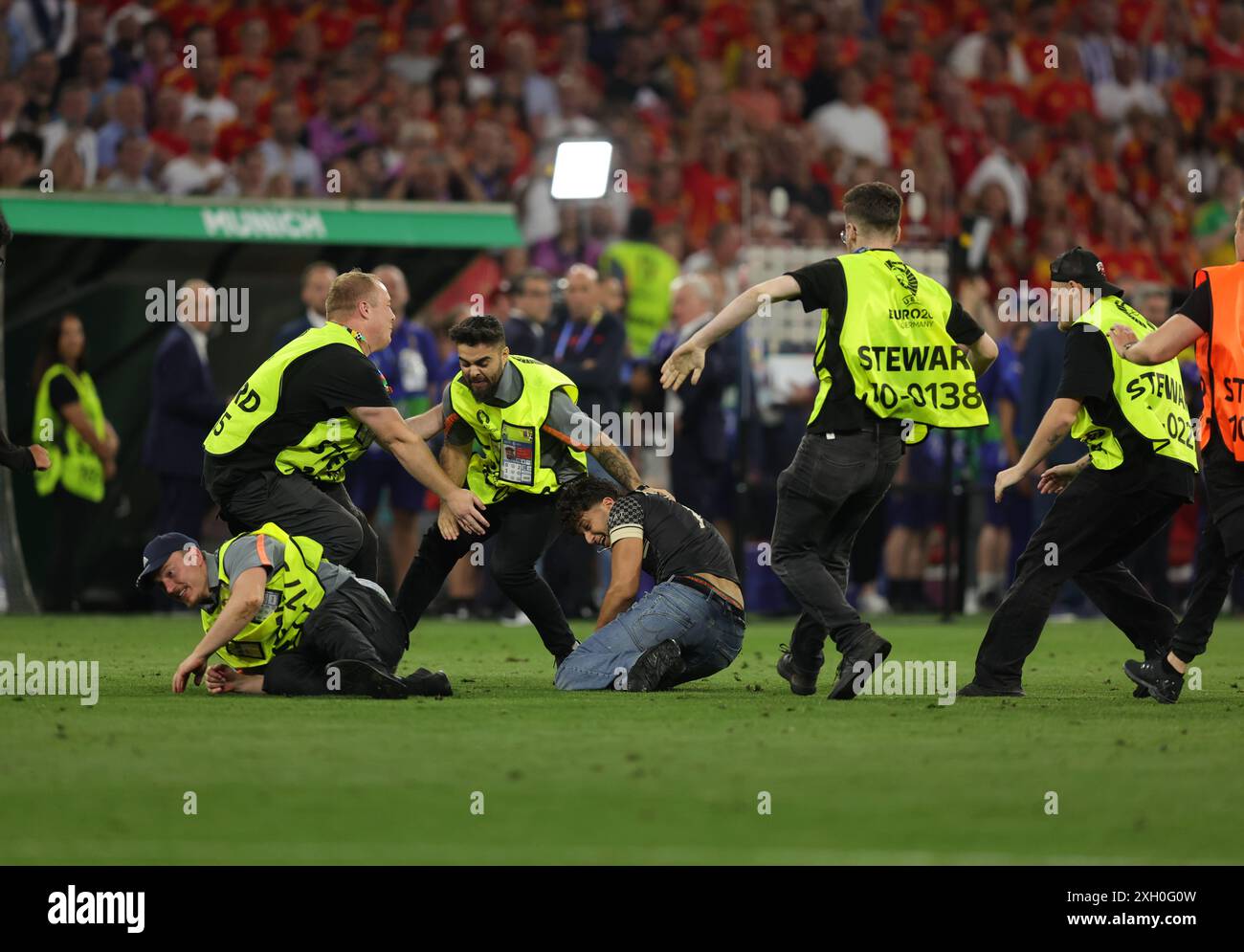 MUNICH, GERMANY - JULY 09: Stewards trying to catch a supporter running ...