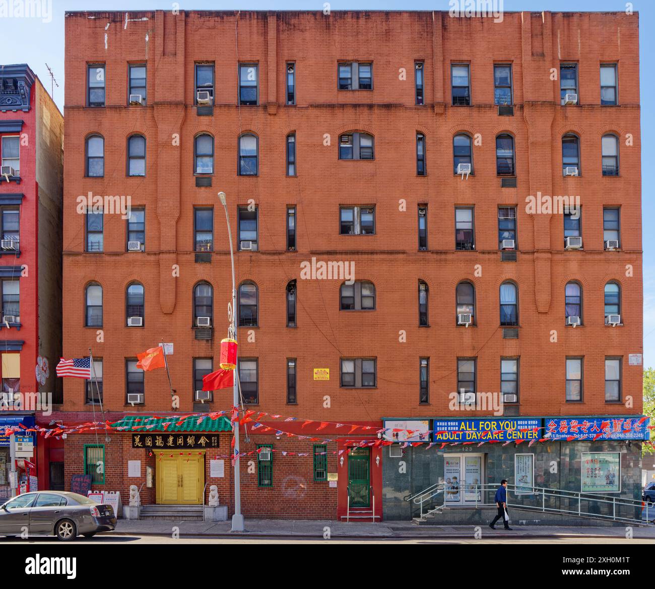 NYC Chinatown: A low-rise, plain, painted brick apartment building and ...