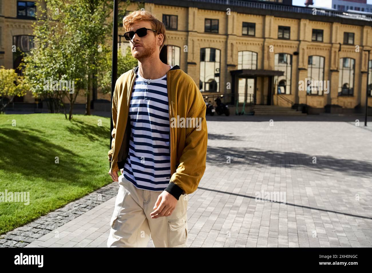 A young red-haired man in debonair attire walking down a city sidewalk ...