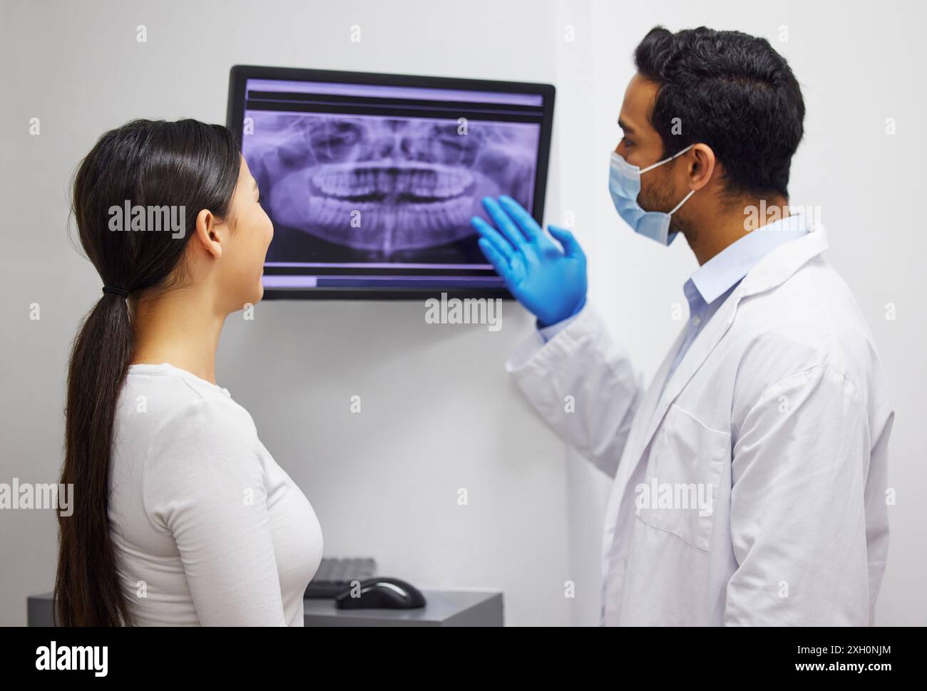Dentist, discussion and x ray of teeth on screen for patient education ...