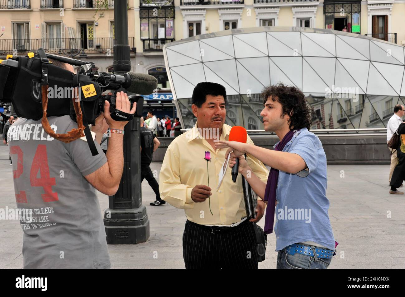 Madrid, Spain, Europe, A reporter interviews a man on a busy street ...