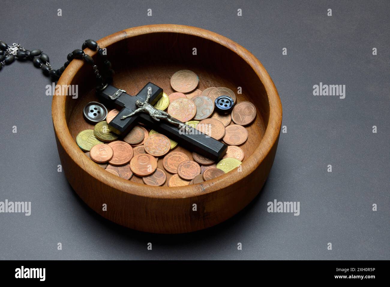 Crucifix with coins and buttons in a wooden bowl, church and money ...