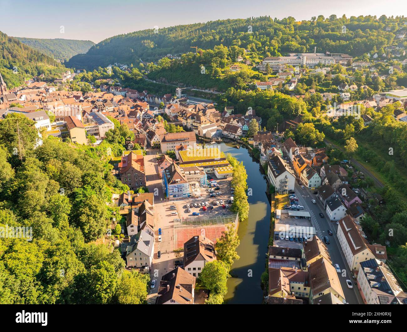 Aerial view of a town with river and car parks, embedded in a hilly ...