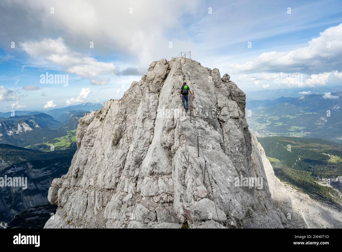Mountaineer on a narrow rocky ridge on a steel cable, Watzmann crossing ...