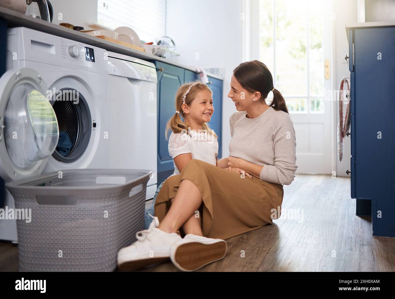 Cleaning, laundry or washing machine with mother and daughter on floor ...