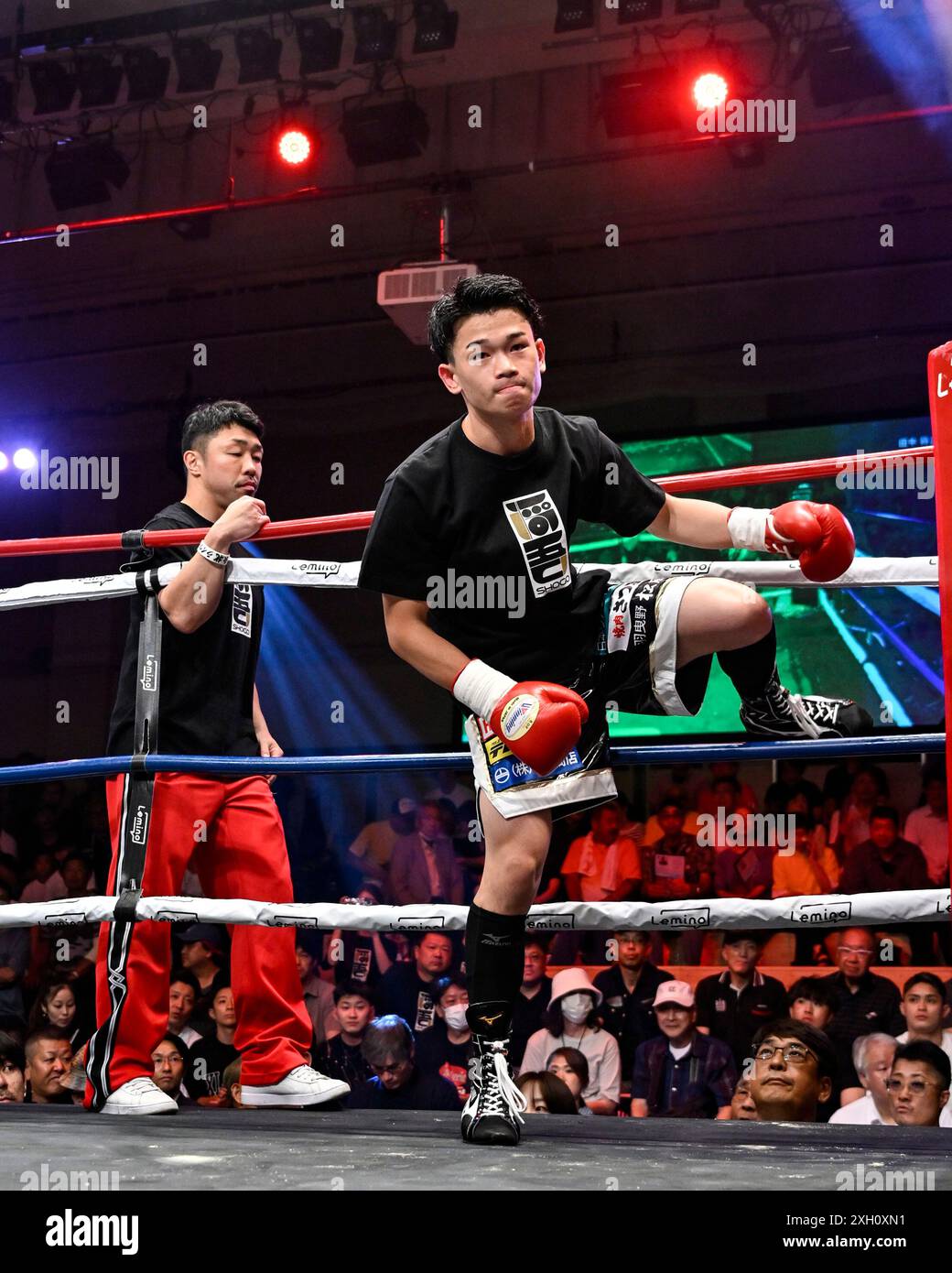 Japan's Shogo Tanaka, right, enters the ring with trainer Akira Yaegashi before his pro debut's ...