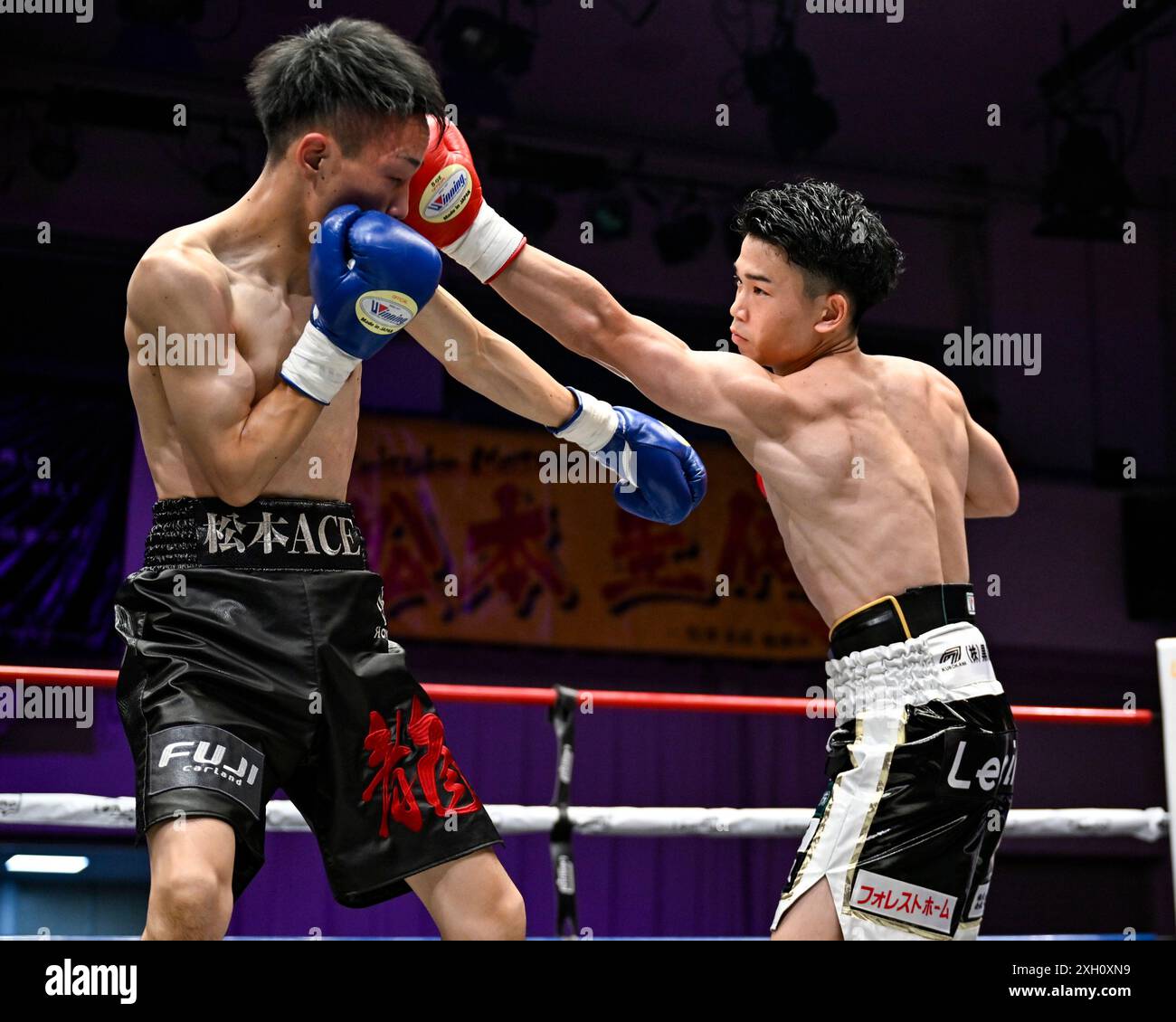 Shogo Tanaka (red gloves) hits Ryunosuke Takaguma (blue gloves) in the ...