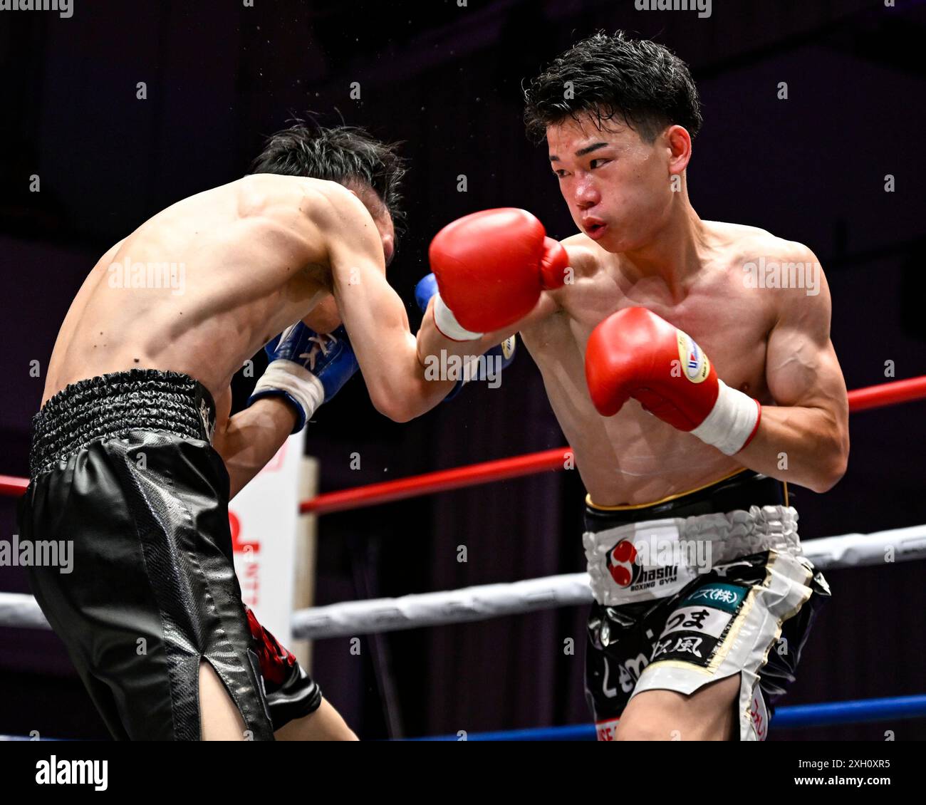 Shogo Tanaka (red gloves) throws a right at Ryunosuke Takaguma (blue ...