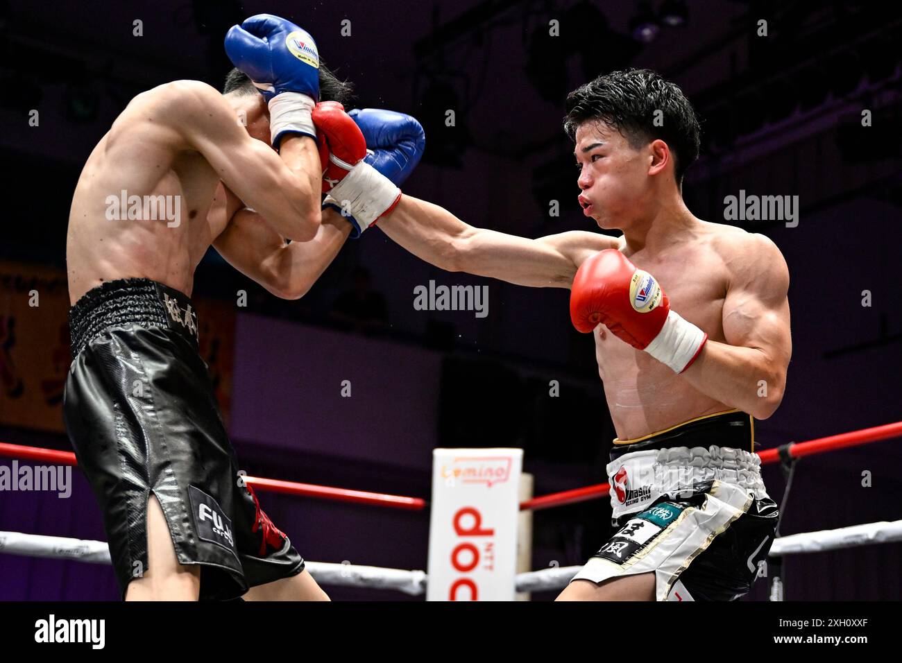 Shogo Tanaka (red gloves) throws a right at Ryunosuke Takaguma (blue ...