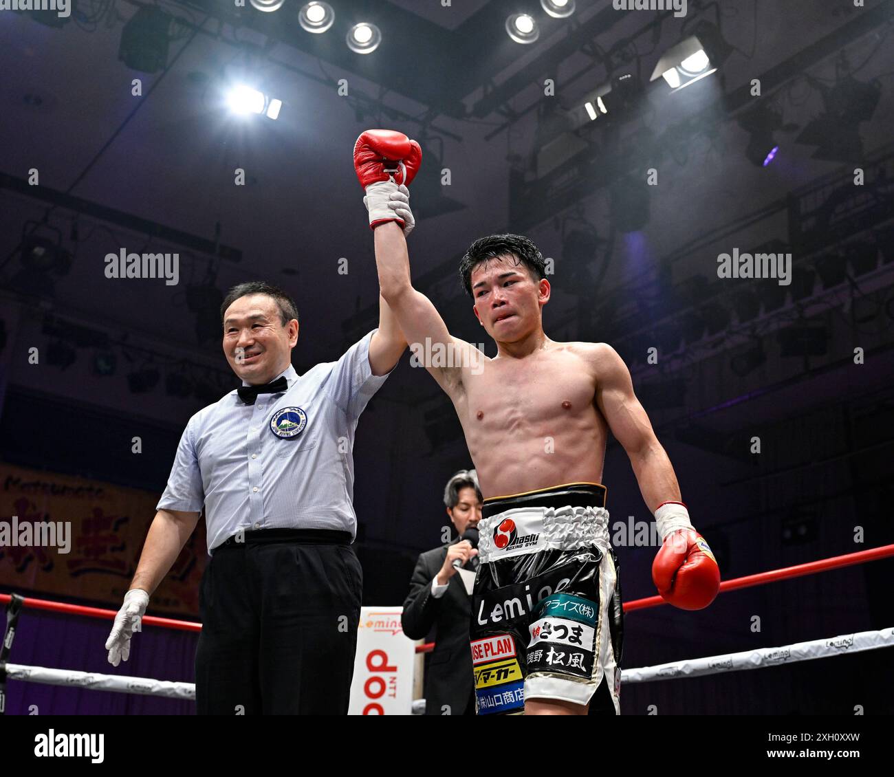Japan's Shogo Tanaka, right, has his right arm raised by referee ...