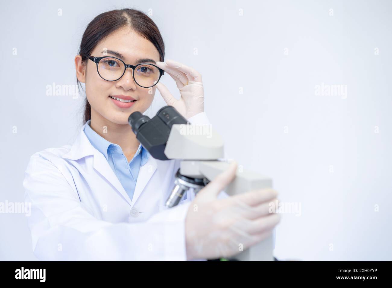 A female scientist is working with a microscope Stock Photo - Alamy