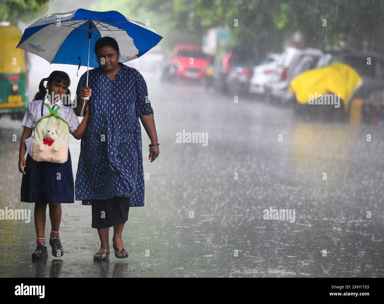 NOIDA, INDIA - JULY 9: Commuters step out during morning rain, which ...