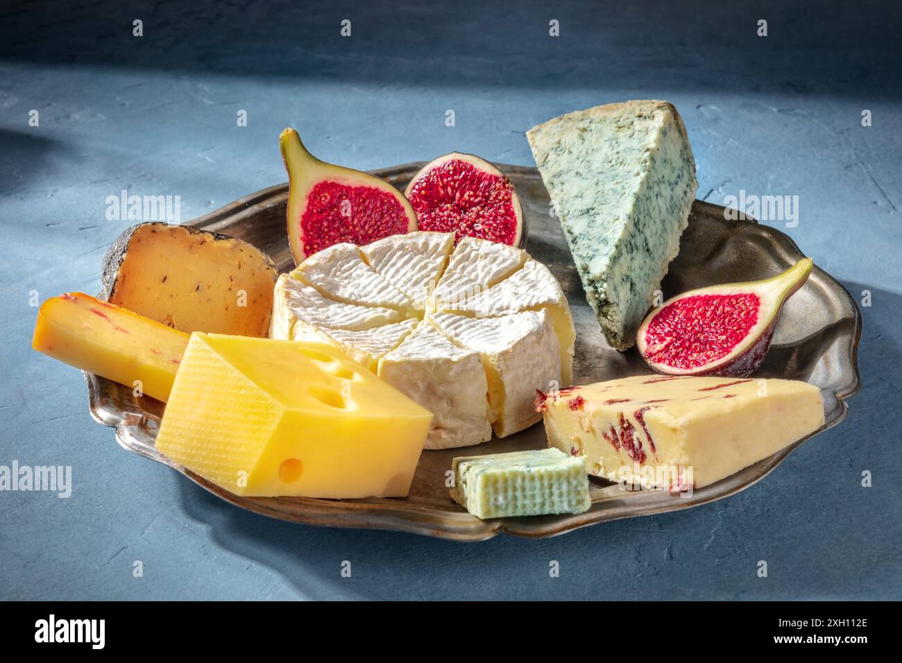 Cheese platter with Brie, blue cheese, and fruit. Delicious variety ...