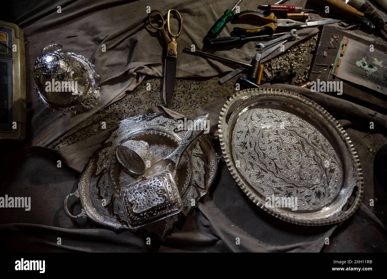 Items made by silversmiths are seen in a workshop in Srinagar. The last ...