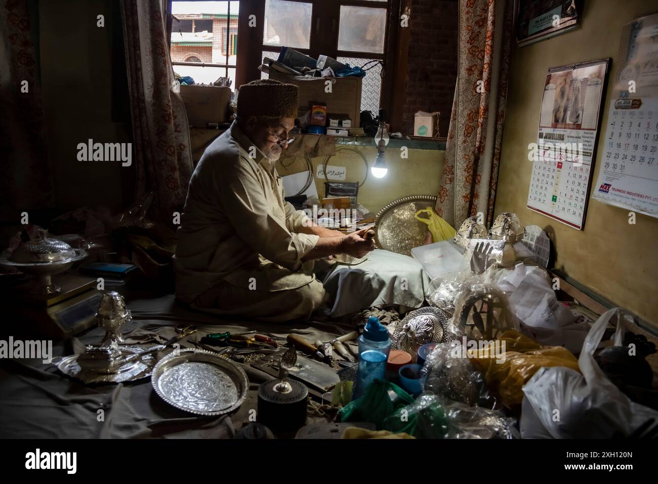 A Kashmiri silversmith is seen working in his workshop in downtown ...