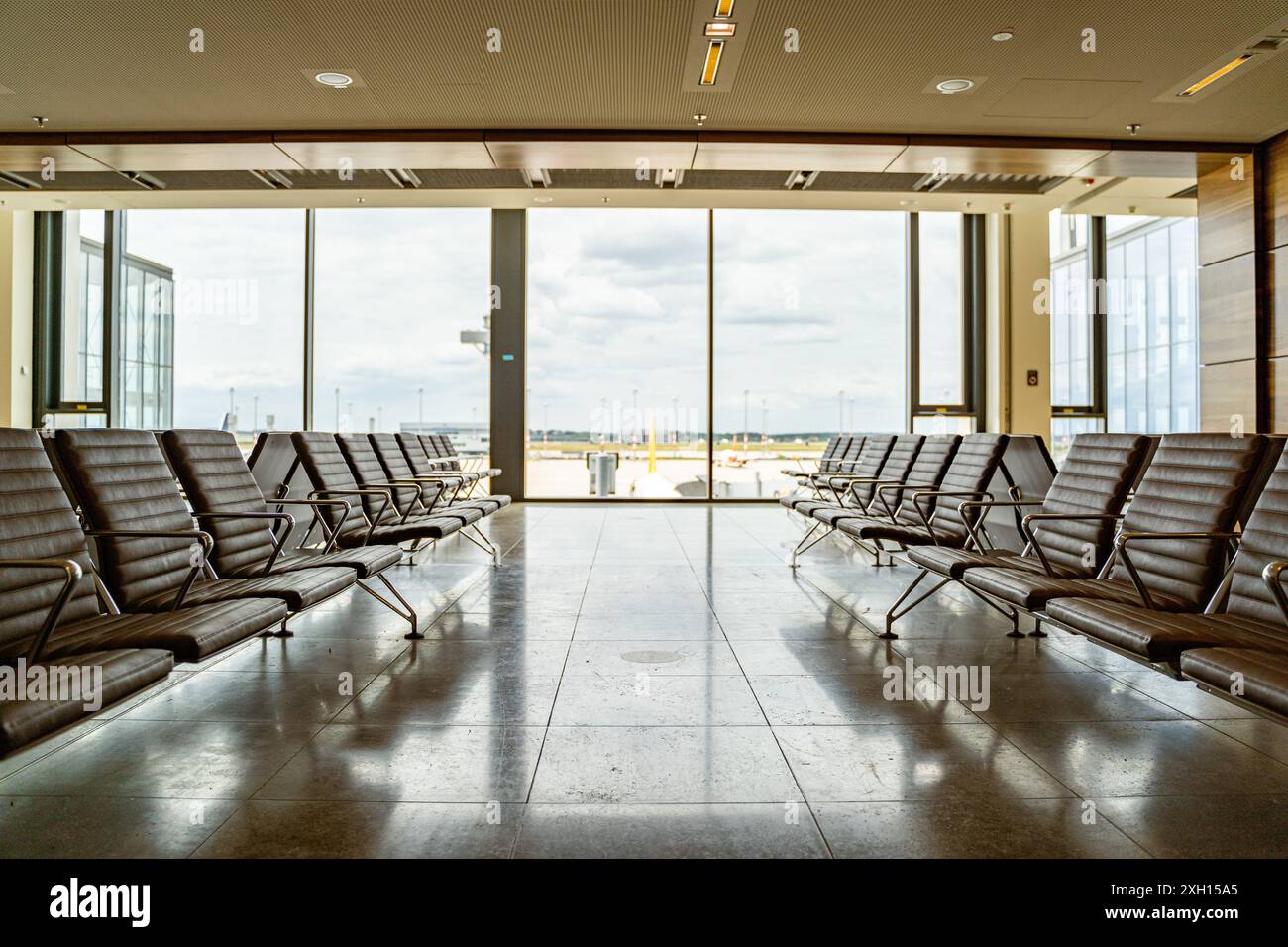 Seating area in modern airport terminal with sunlight through large ...