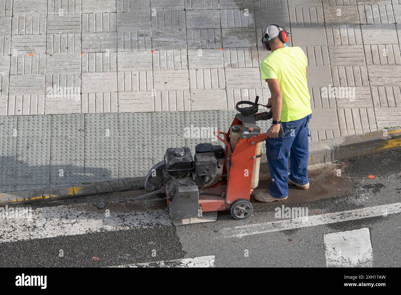 Construction worker cutting concrete floor with diamond saw blade ...