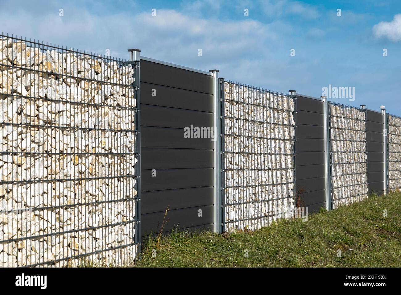Privacy screen made of wood and stones Stock Photo - Alamy