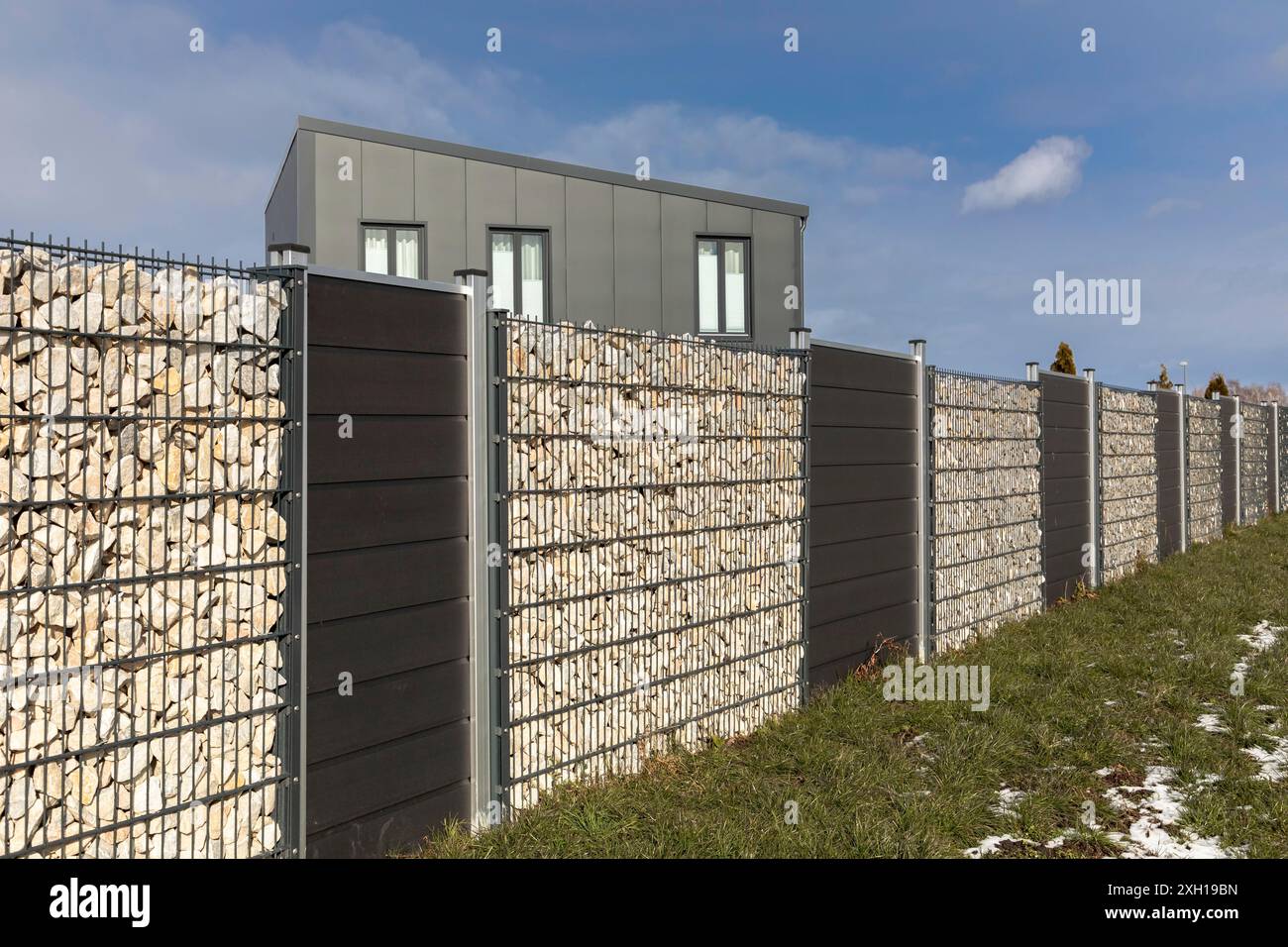Privacy screen made of wood and stones Stock Photo - Alamy