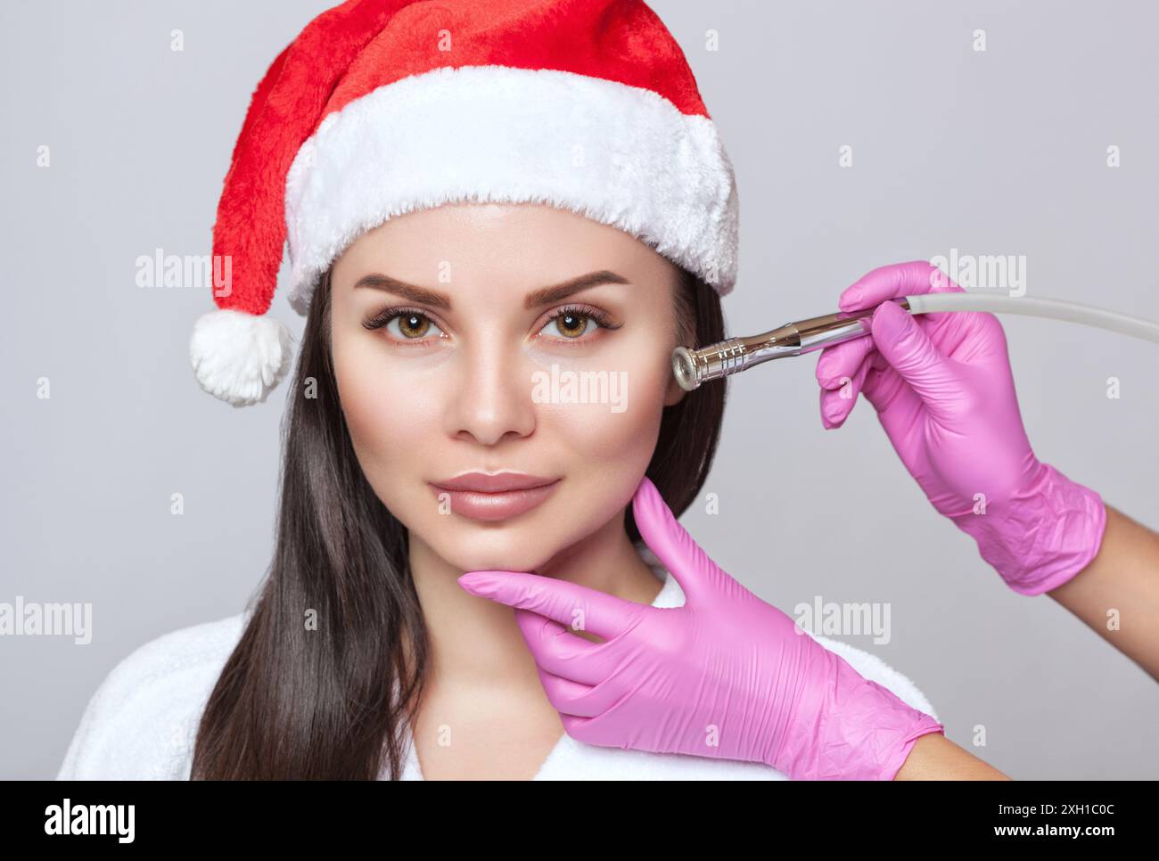 Cosmetologist does the procedure Microdermabrasion on the face of a ...