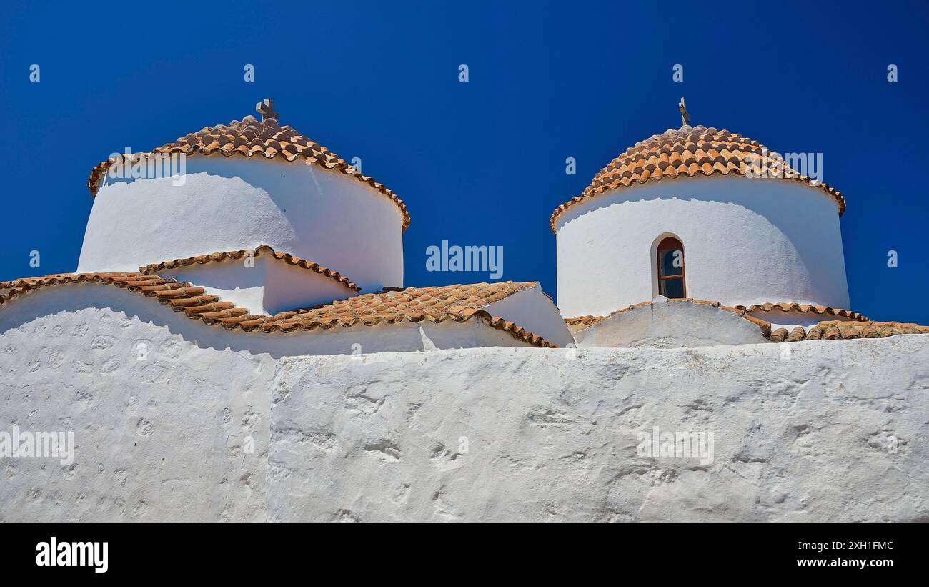 Two white painted church towers with red tiled roofs and small windows ...