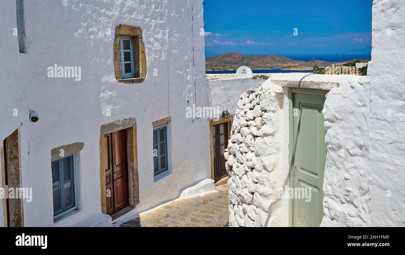 Narrow alley with white walls and wooden doors, view of the ...